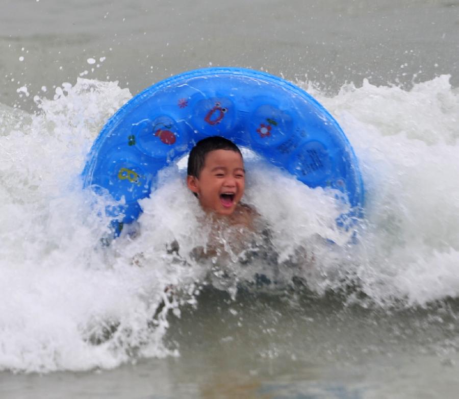 Tourists amuse themselves on beach in China's Sanya - China.org.cn